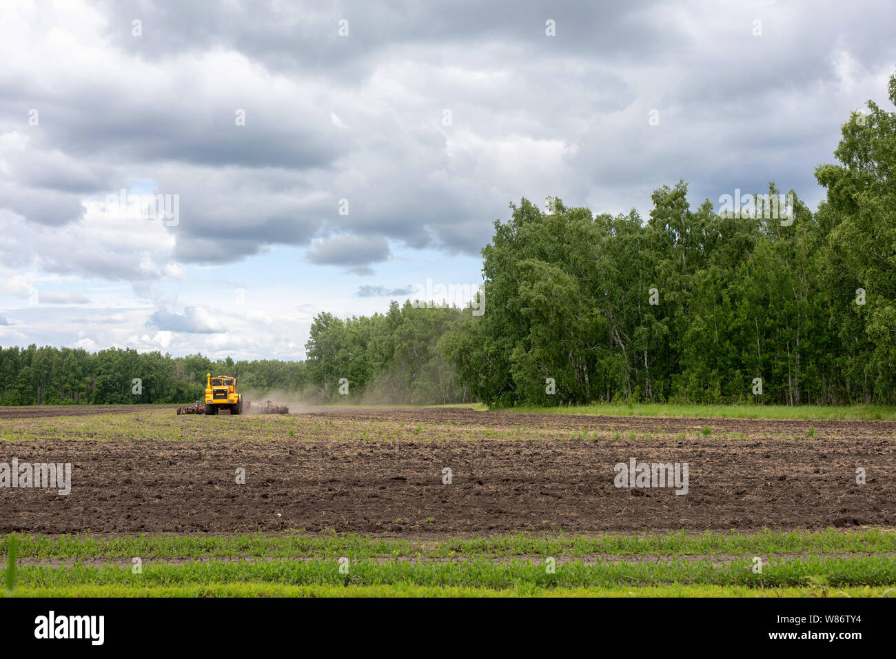 Ploughing Tractor At Field Cultivation Work. The machine plows the ...
