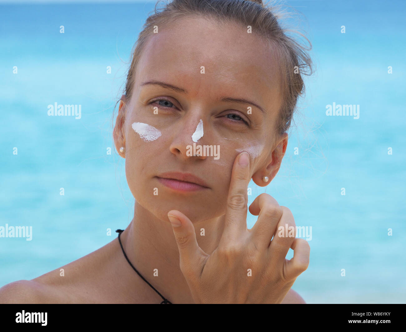Woman applying sunscreen to face hi-res stock photography and images ...