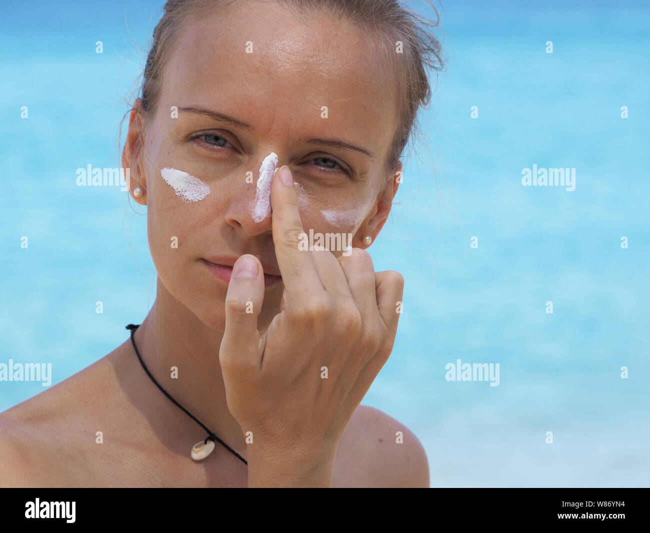Woman applying sunscreen to face hi-res stock photography and images ...