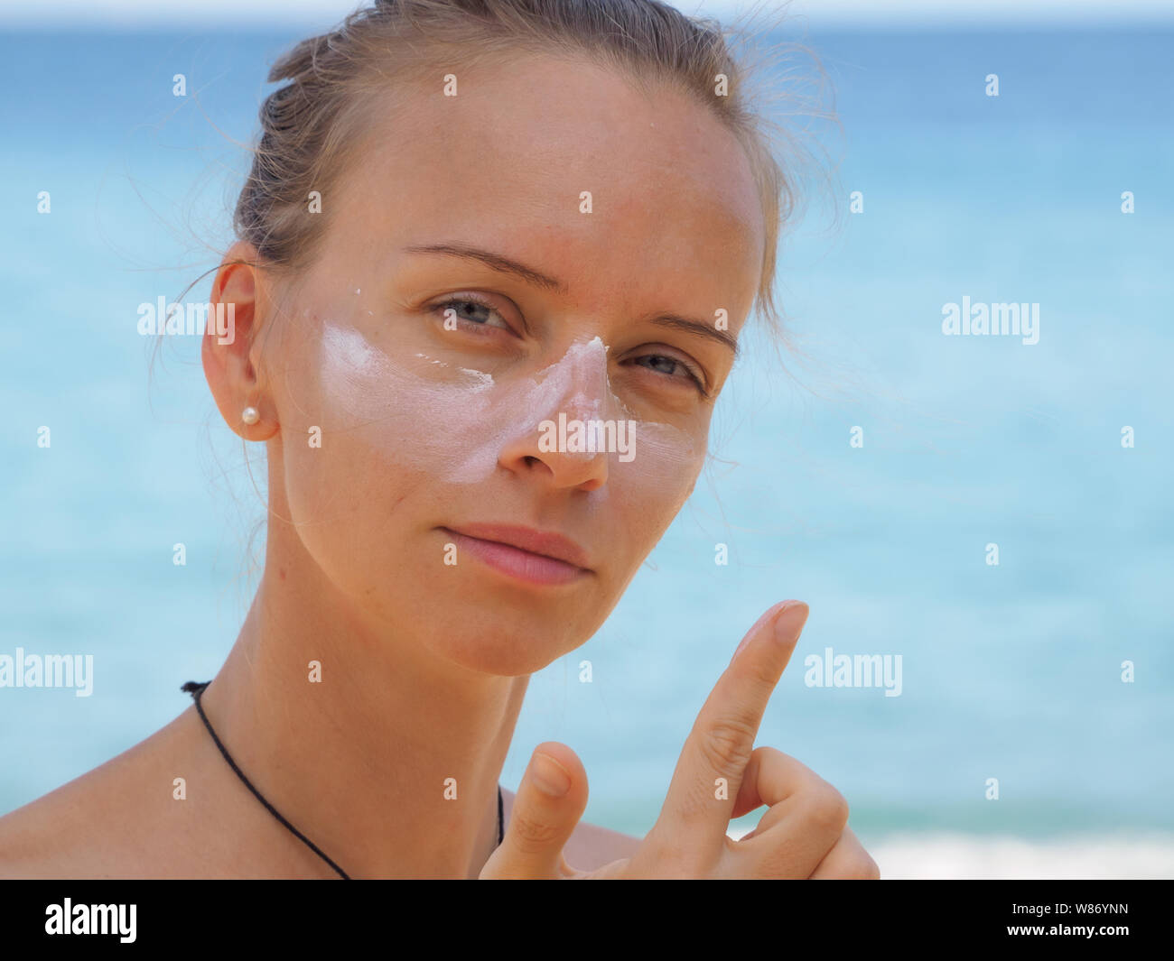 Portrait Of A Beautiful Slim Girl Wearing A Bikini Puts On Her Face