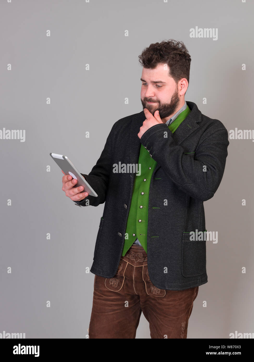 young and cool austrian man with black hair and beard in traditional ...