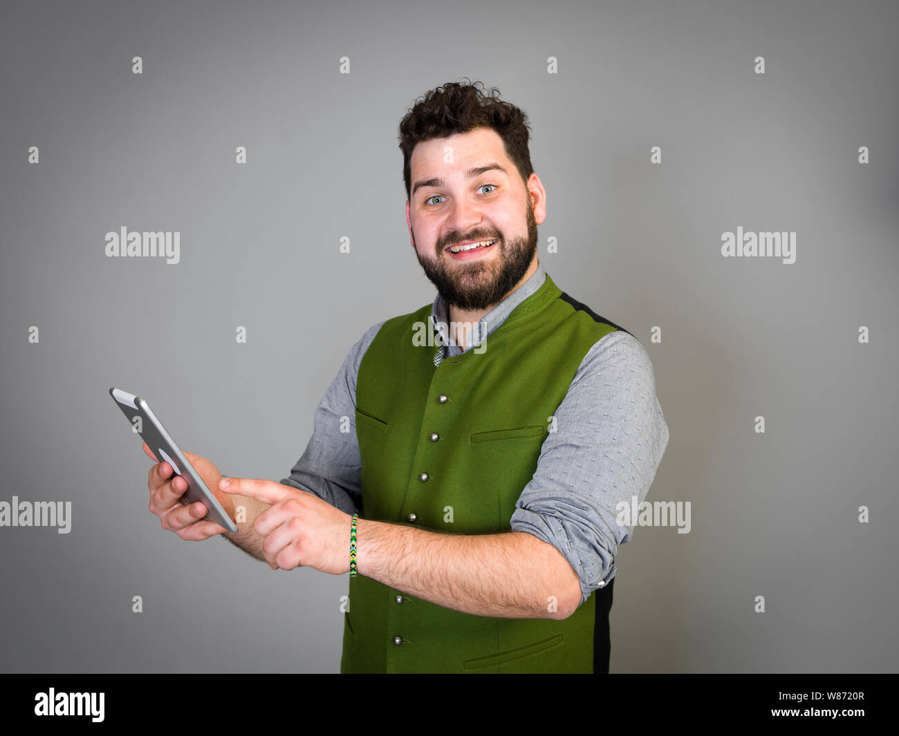 young and cool austrian man with black hair and beard in traditional ...