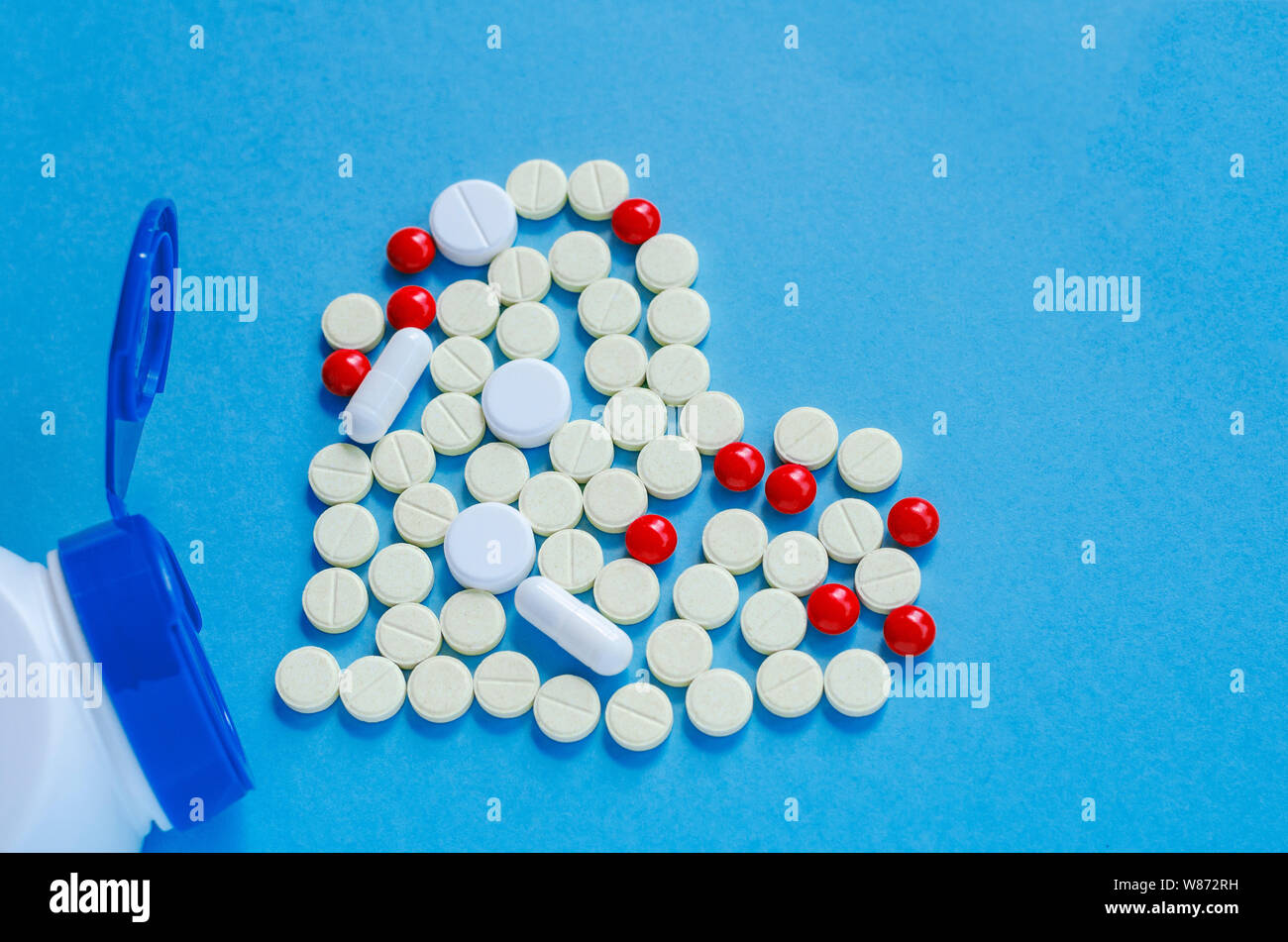 The white heart pills on a colored background. The concept of a healthy ...