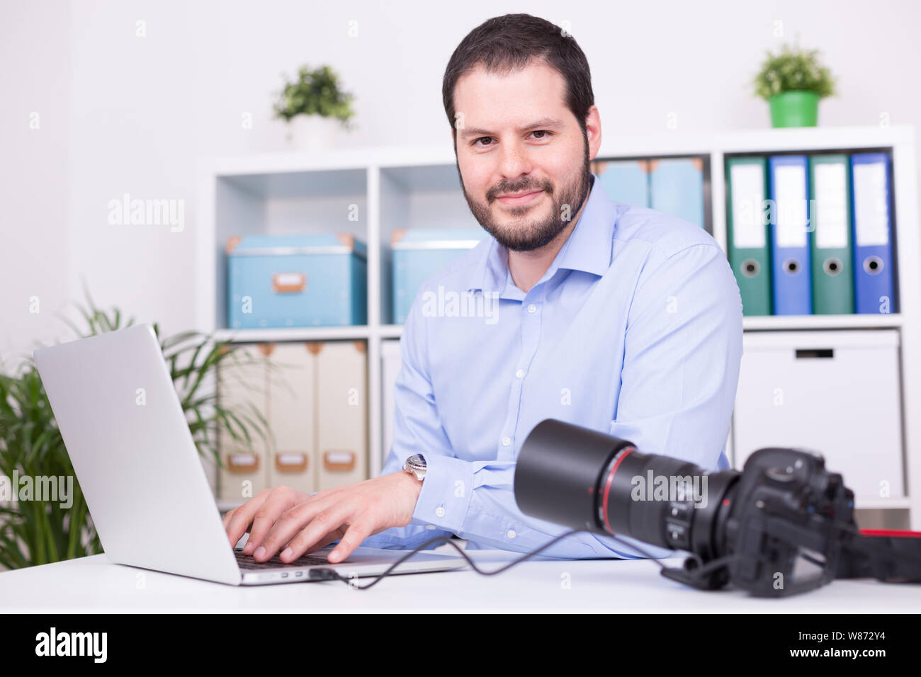 Bearded photographer at his office with laptop and camera Stock Photo ...