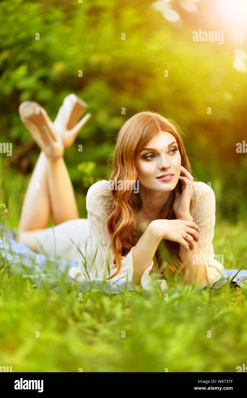 Beautiful woman lying on green hi-res stock photography and images - Alamy