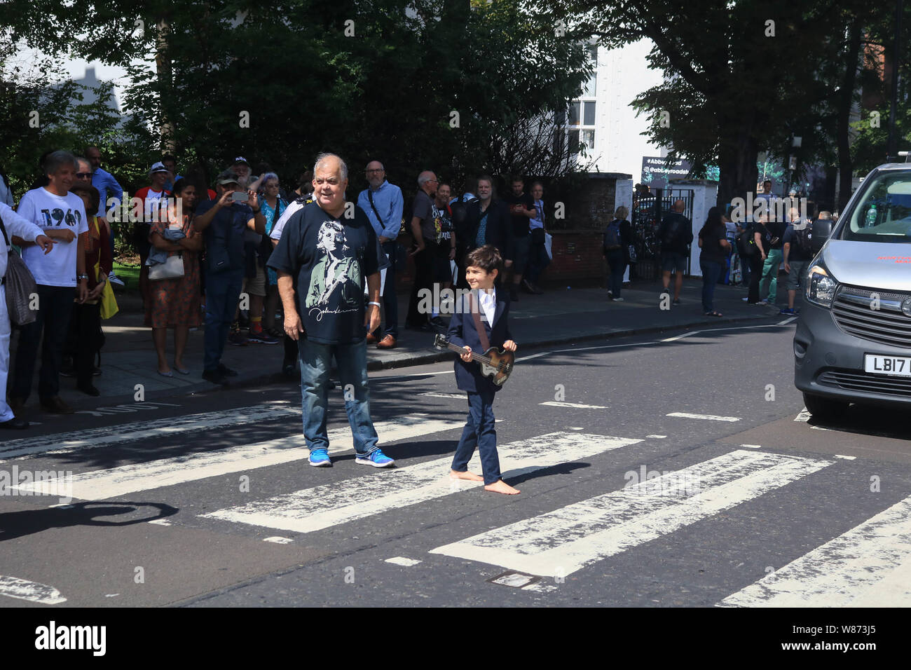London, UK. 8th Aug, 2019. A young Beatles walks barefoot as he ...