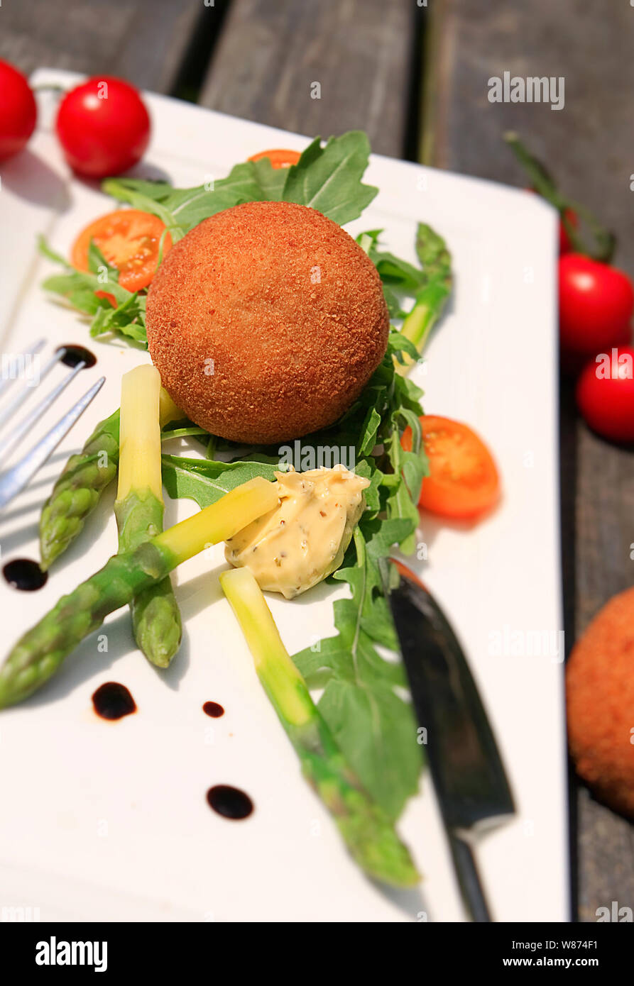 Breaded fish shaped into a ball and covered in breadcrumbs for a ...