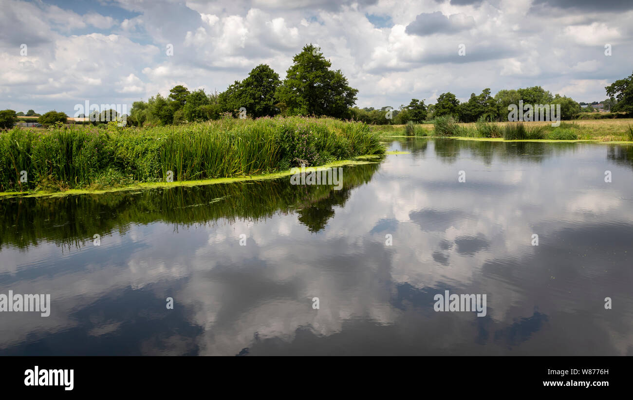 the river stour at fiddleford mill with clouds and reflections in river ...
