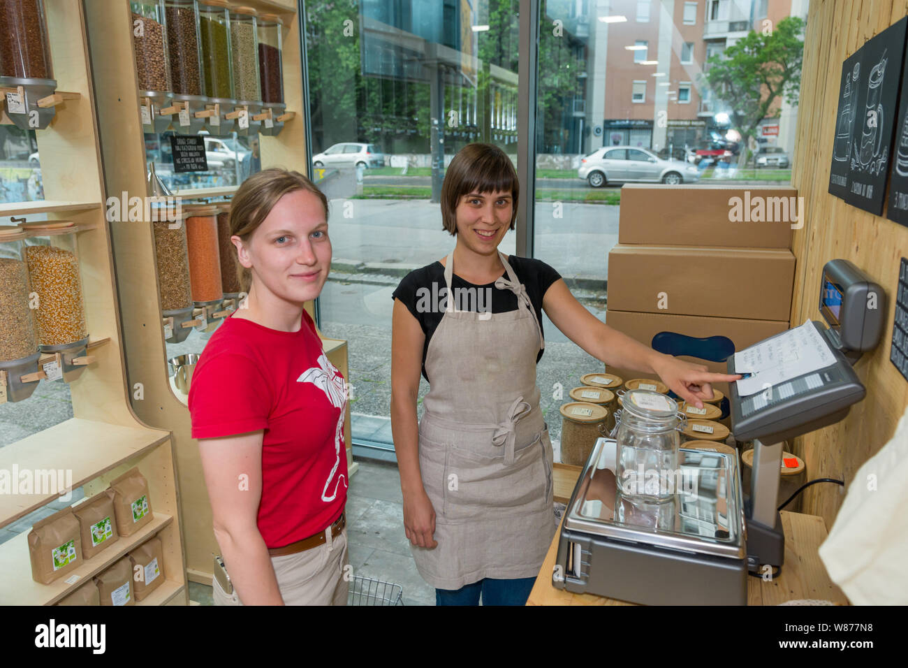 Female shopkeeper helping a customer in zero waste store Stock Photo ...