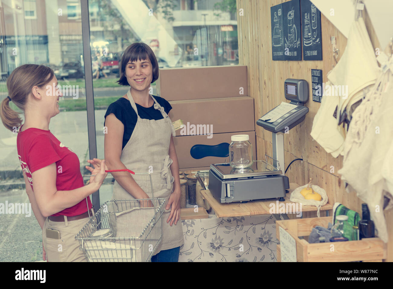 Female shopkeeper helping a customer in zero waste store Stock Photo ...