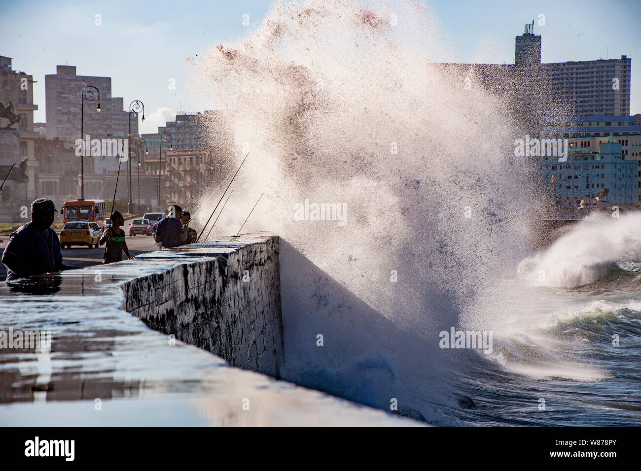 Havana, Cuba, Nov 20, 2017 - Waves crash over the Malecon wall as men ...