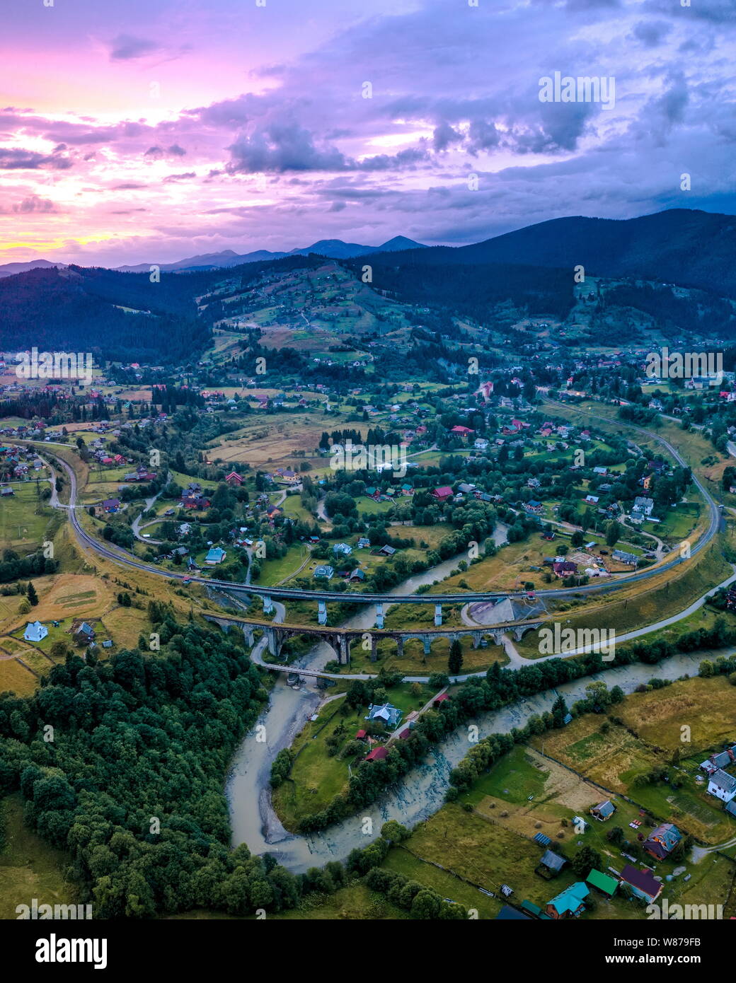 village in the mountains, old bridge viaduct, lilac sunset aerial view ...