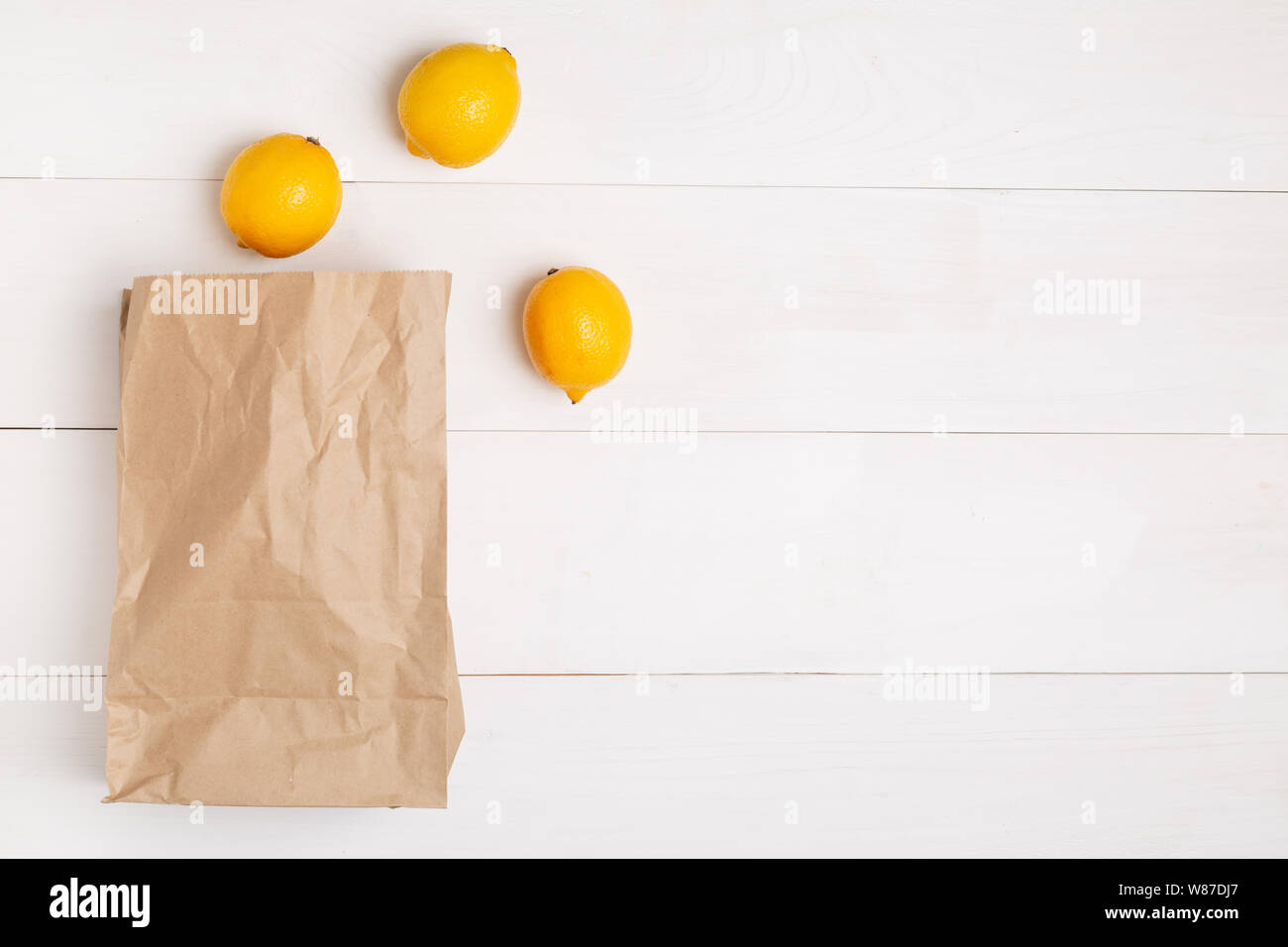 Paper bag on wooden white background with empty space for text. Flat ...