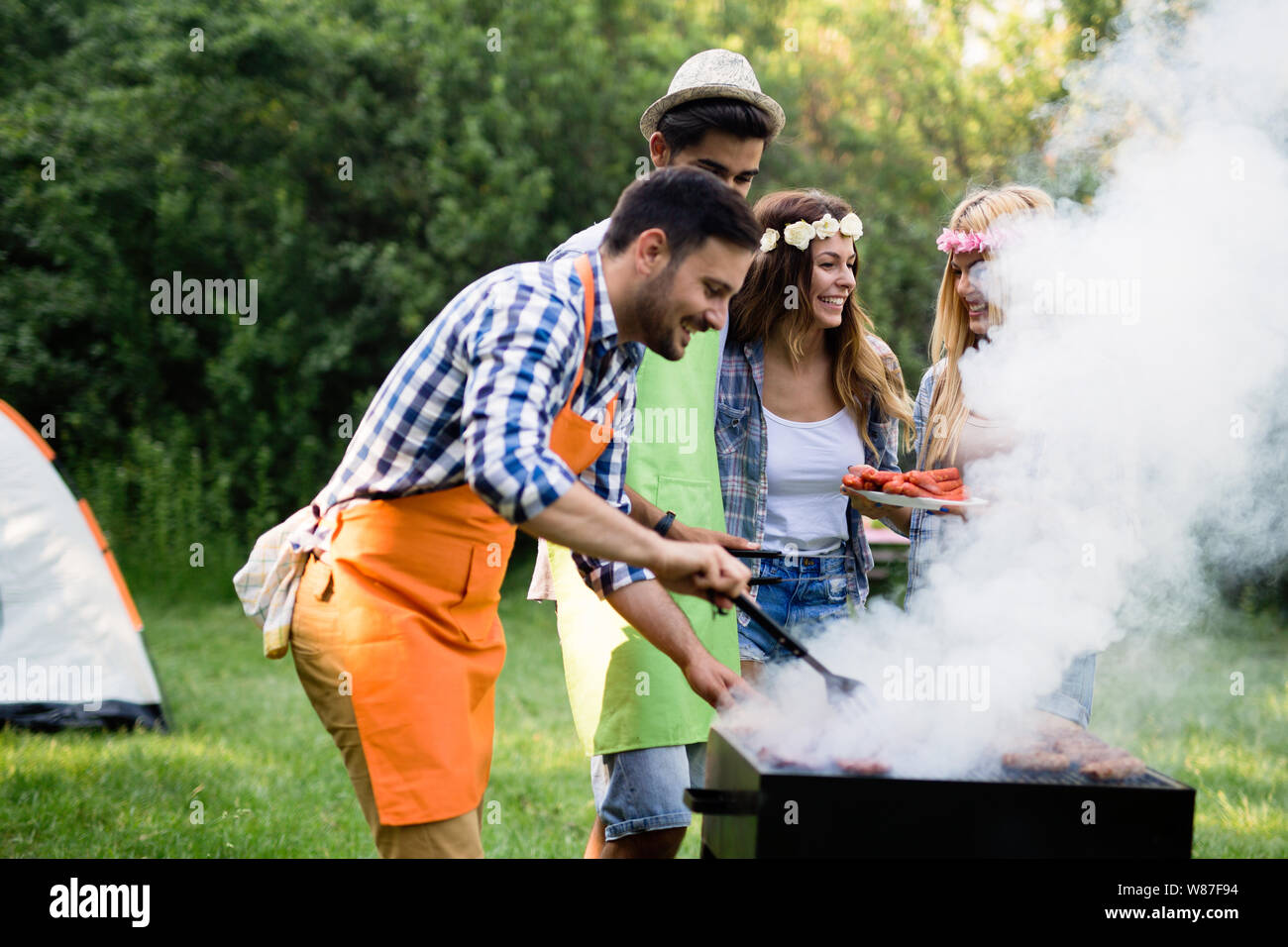 Group of happy friends having outdoor barbecue laughing together Stock ...