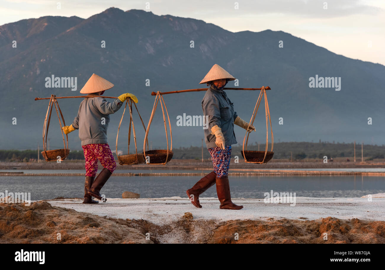woman working hard by carrying heavy salt baskets on their shoulders ...