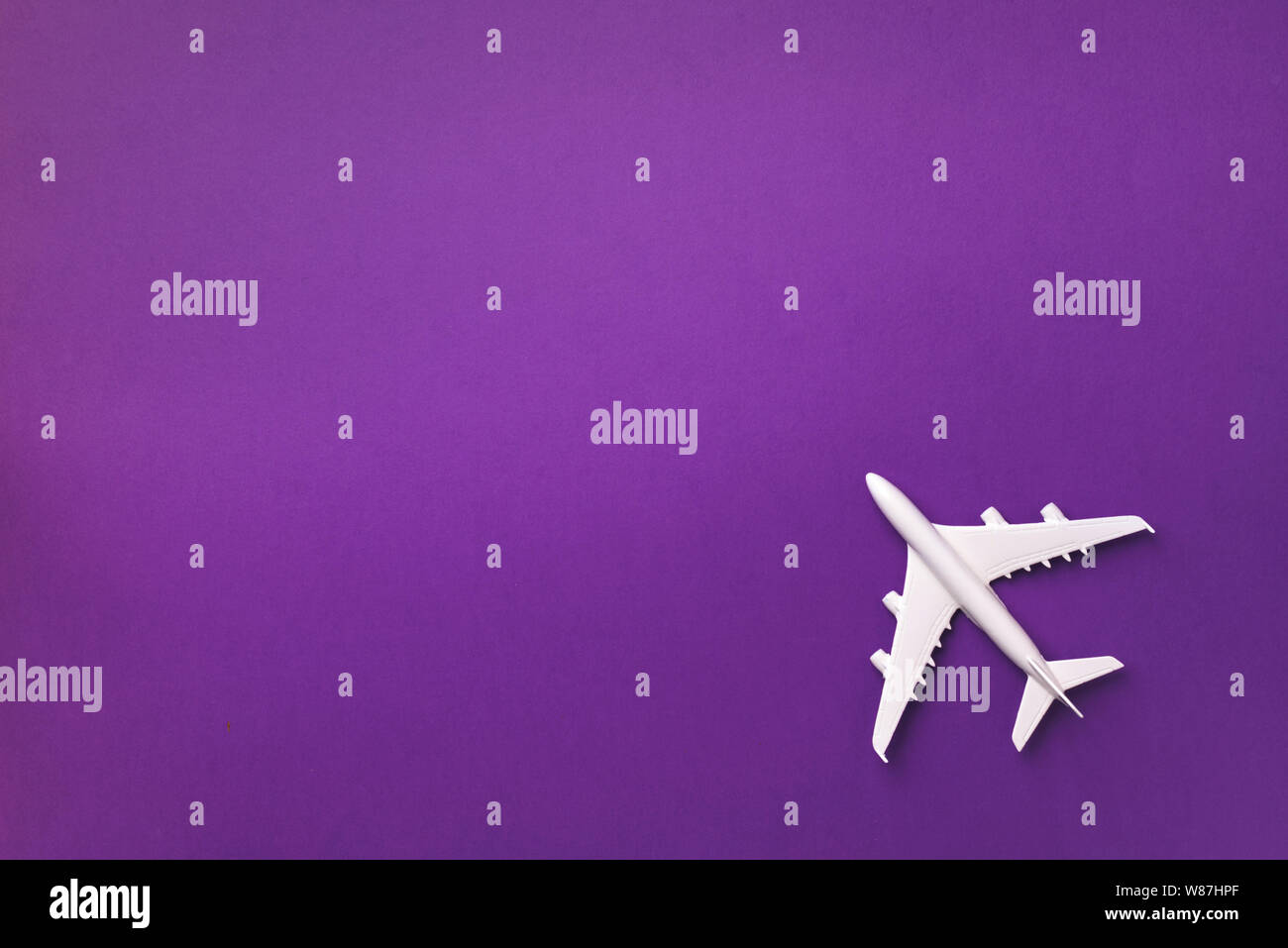 White plane, airplane on violet color background with copy space. Top ...