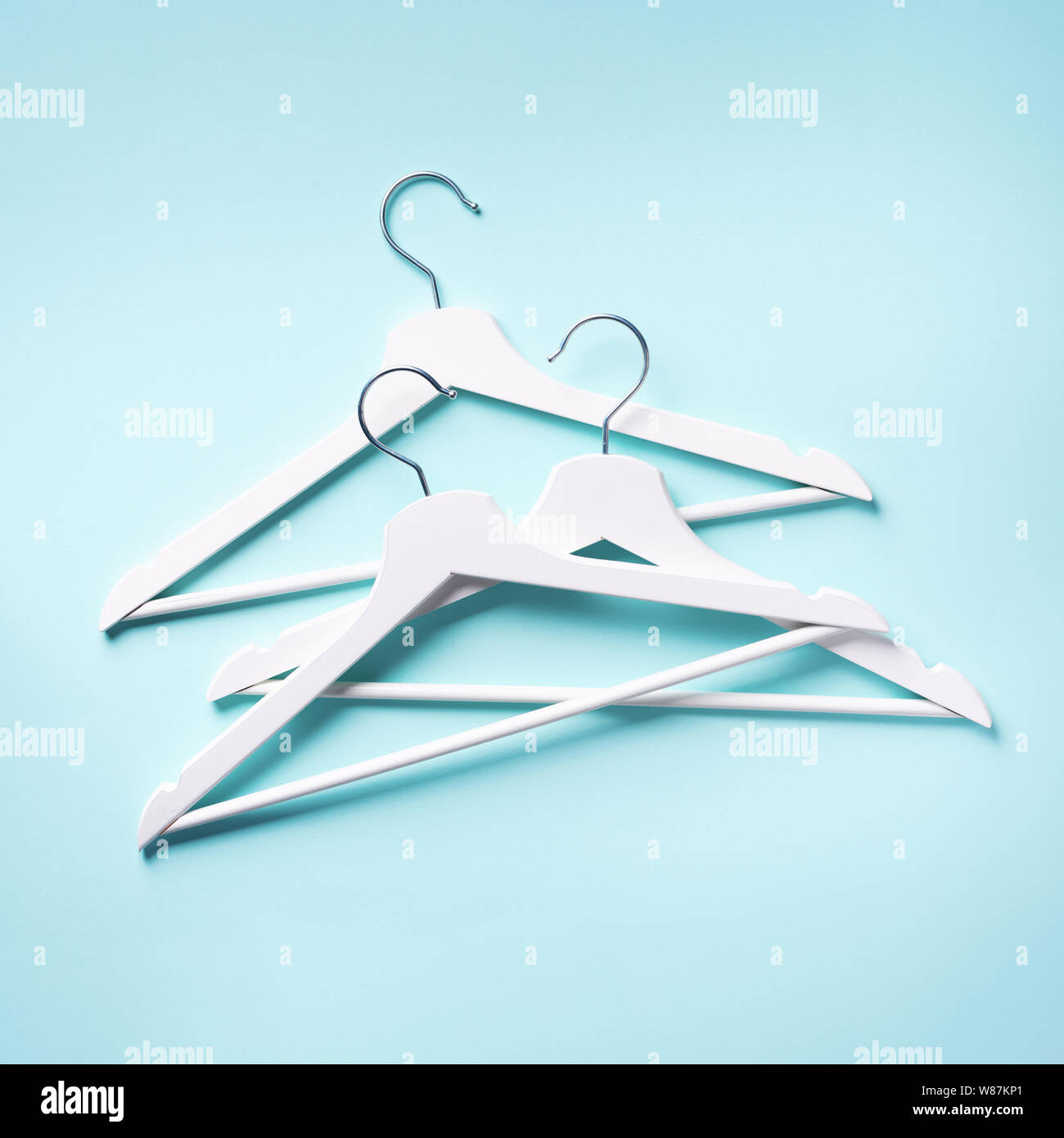 Top view of white clothes hangers on blue background with copy space ...