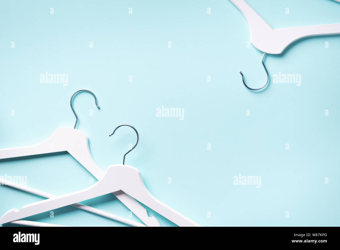 Top view of white clothes hangers on blue background with copy space ...