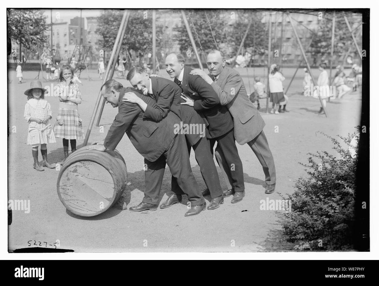 4 men rolling barrel in park Stock Photo - Alamy