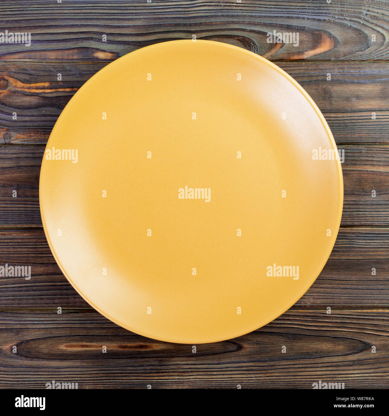 Yellow Round Plate on wooden table background. Top view, template for ...