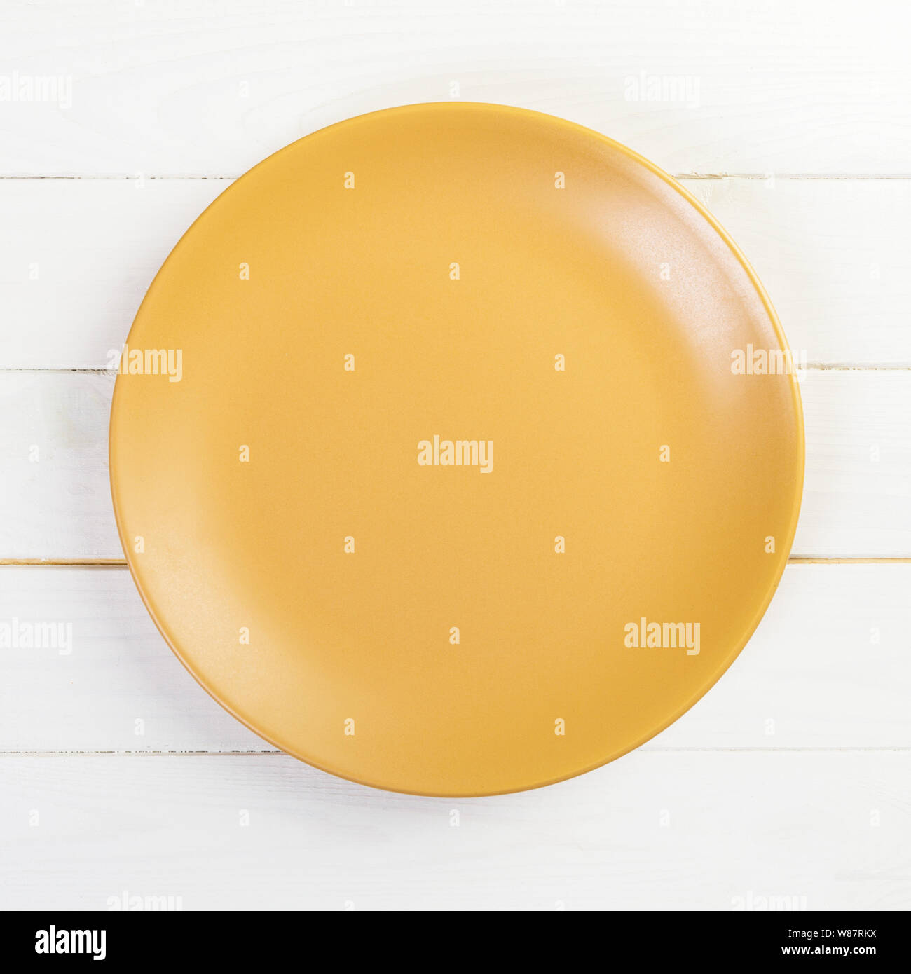Yellow Round Plate on wooden table background. Top view, template for ...