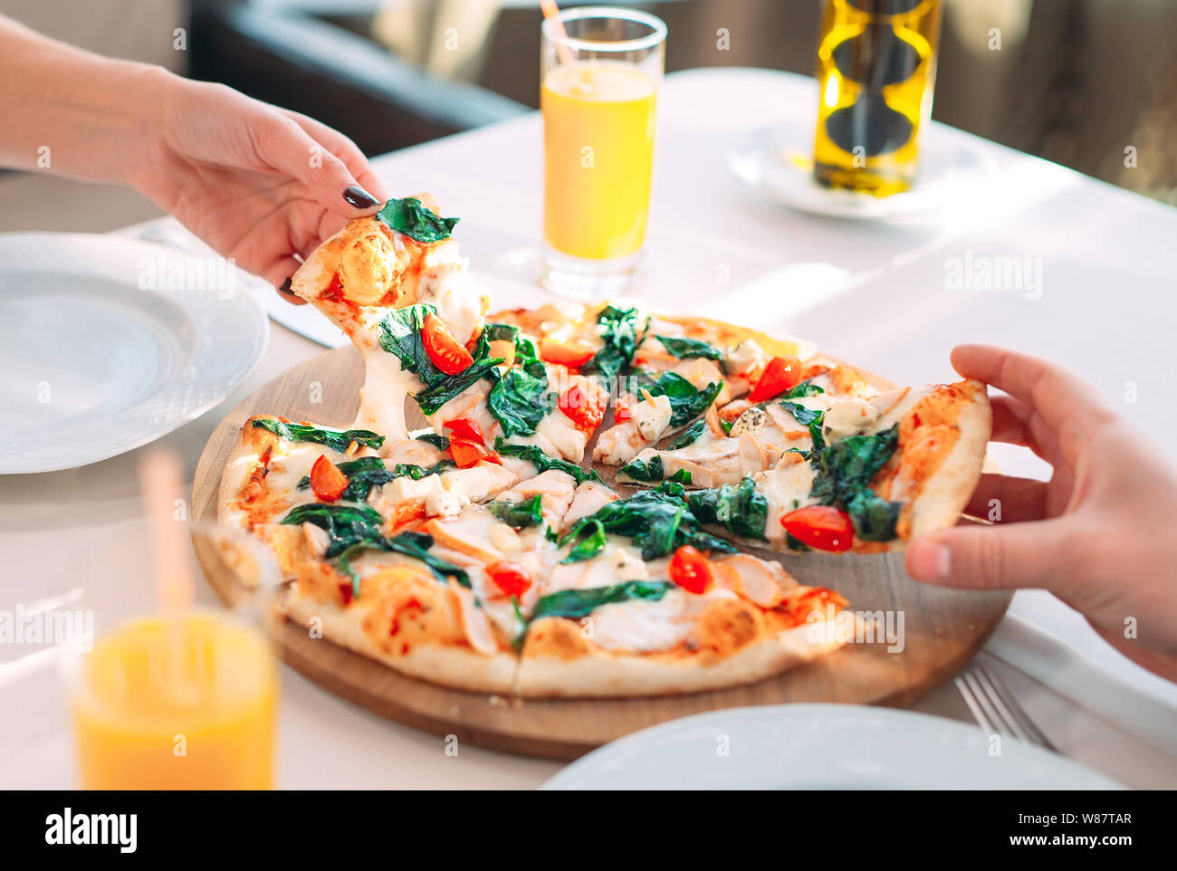 Eating Pizza. Hands close-up take pieces of pizza Stock Photo - Alamy