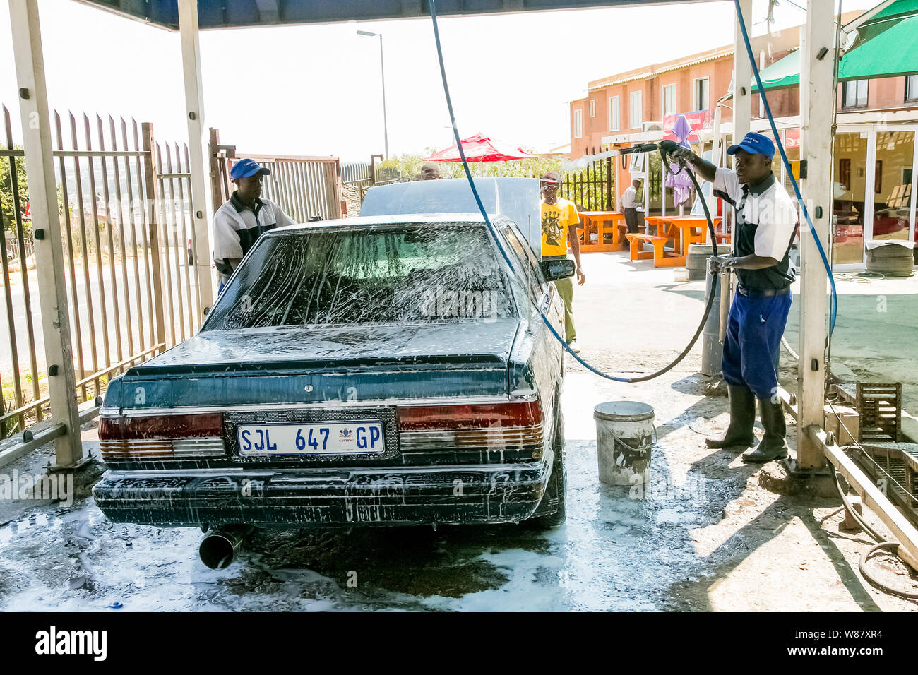 Johannesburg, South Africa - August 29 2013: African Man washing a car ...