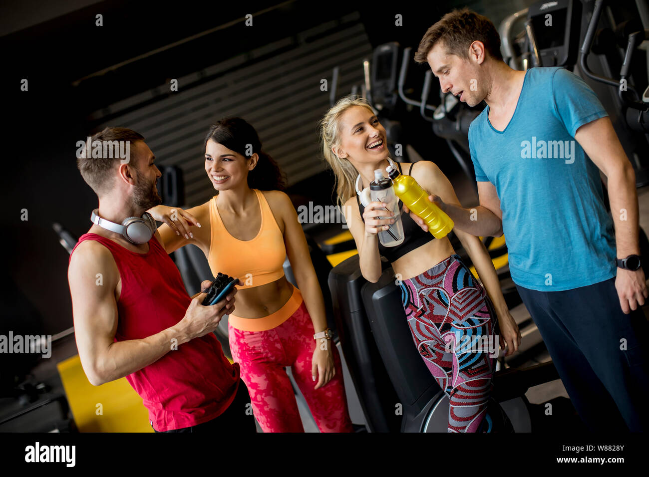 Group of sporty young people standing at the gym Stock Photo - Alamy