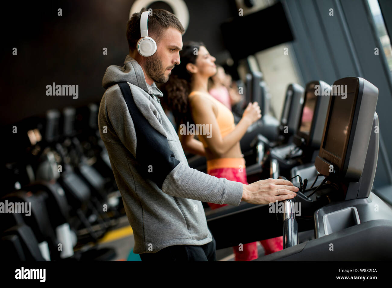 Group of young people using threadmill in modern gym Stock Photo - Alamy