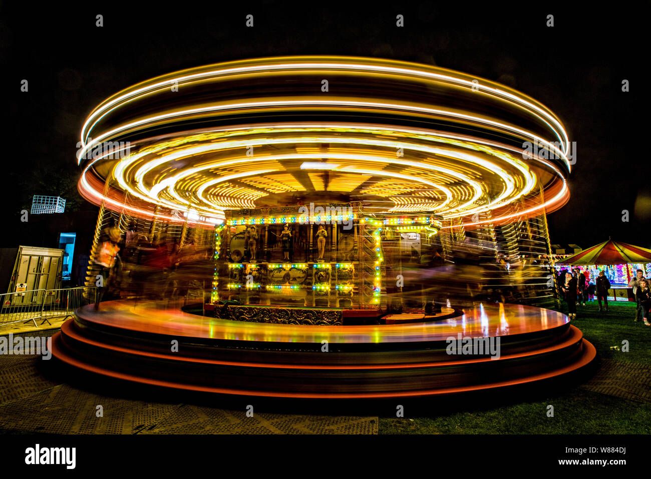 carousel spinning with coloured lights at night Stock Photo - Alamy