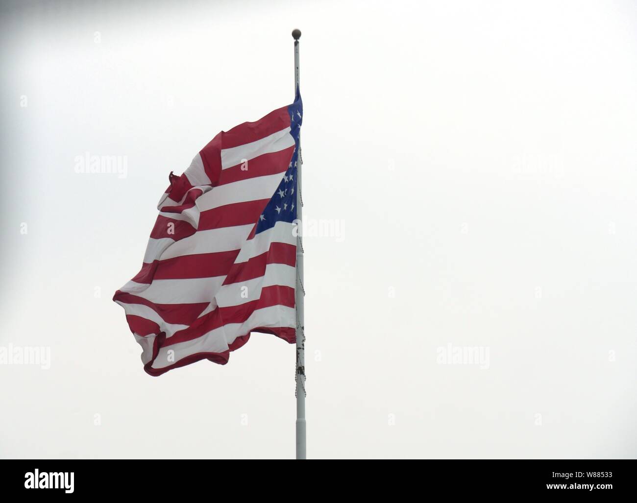 United States flag furled around a pole, in white background Stock ...