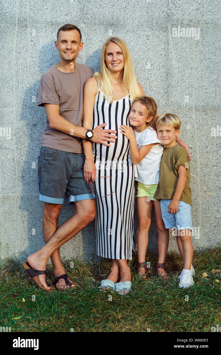 Image of family with children standing near concrete wall on street ...