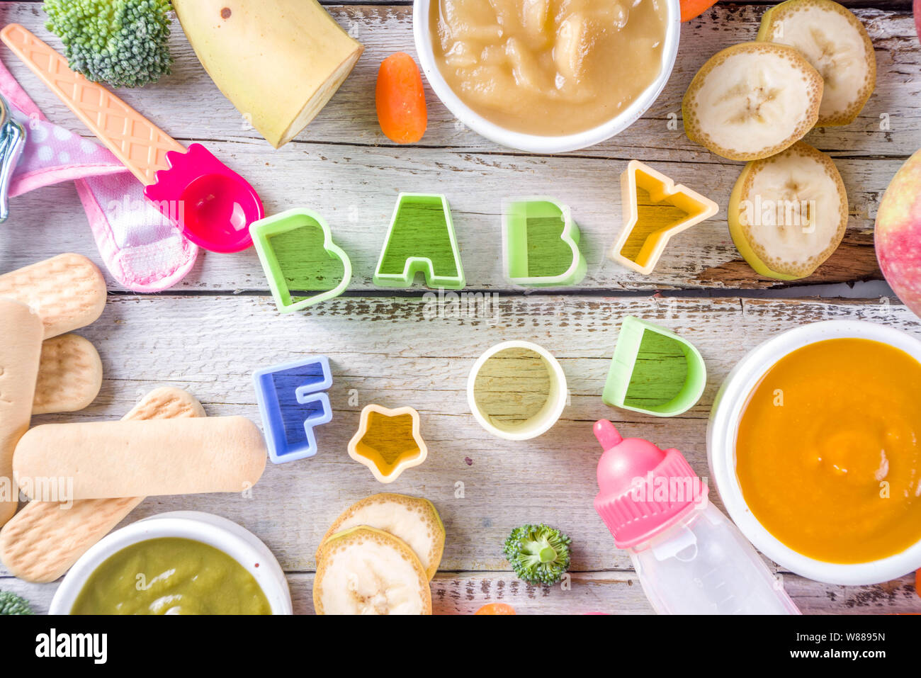 Infant baby food. Bowls with vegetable fruit puree, green, orange ...