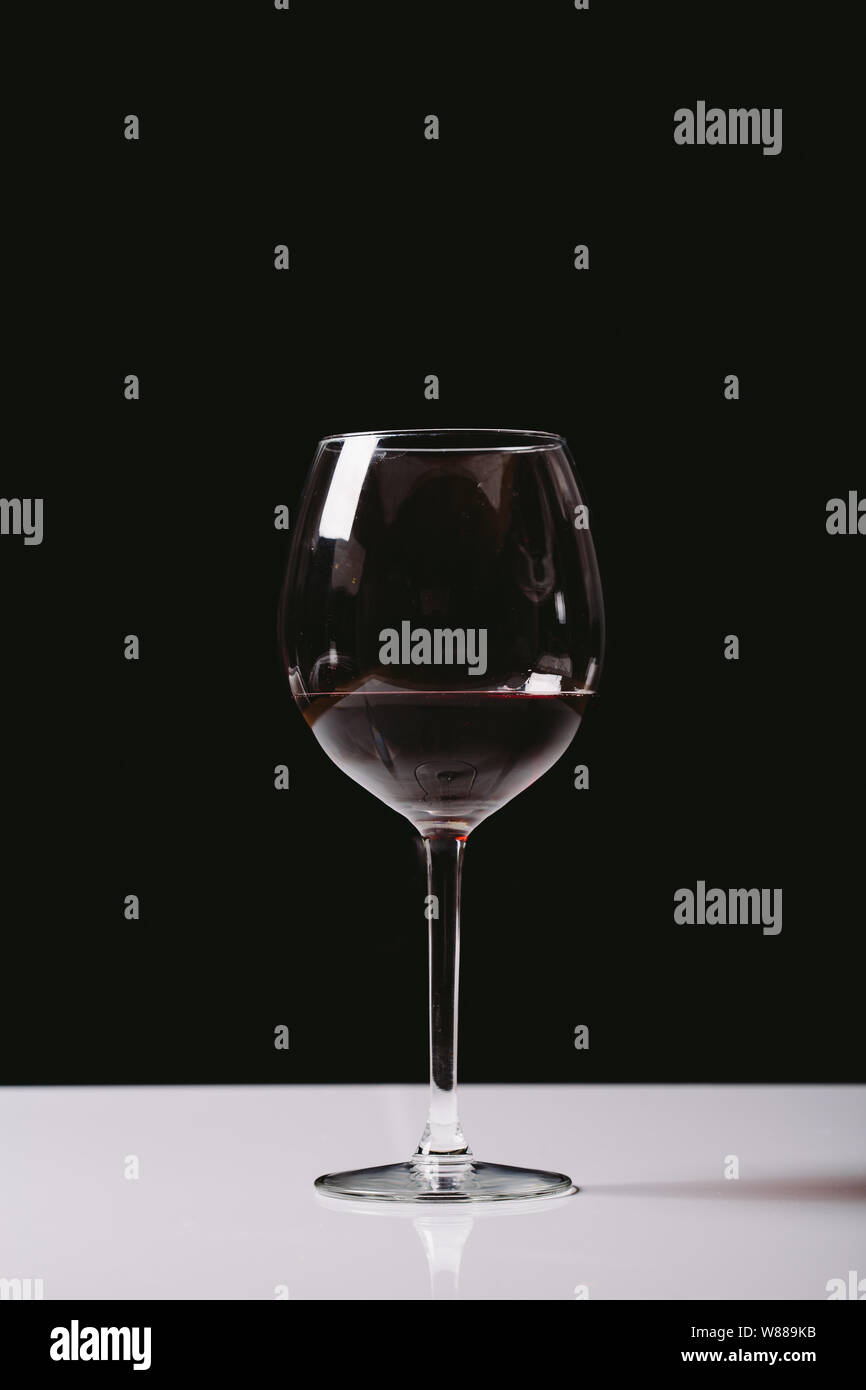 Red wine on a wineglass isolated on a black background dark still Stock ...