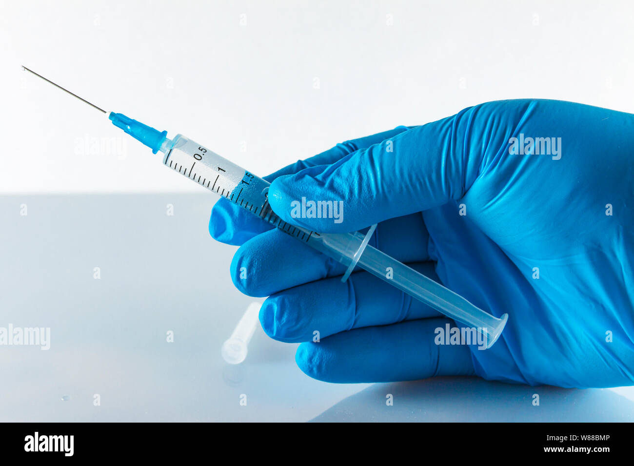 Hand holding syringe isolated on white Stock Photo - Alamy