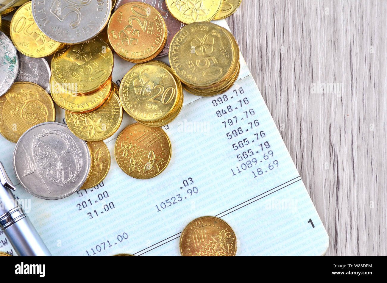 Coins with silver pen on bank account book Stock Photo - Alamy