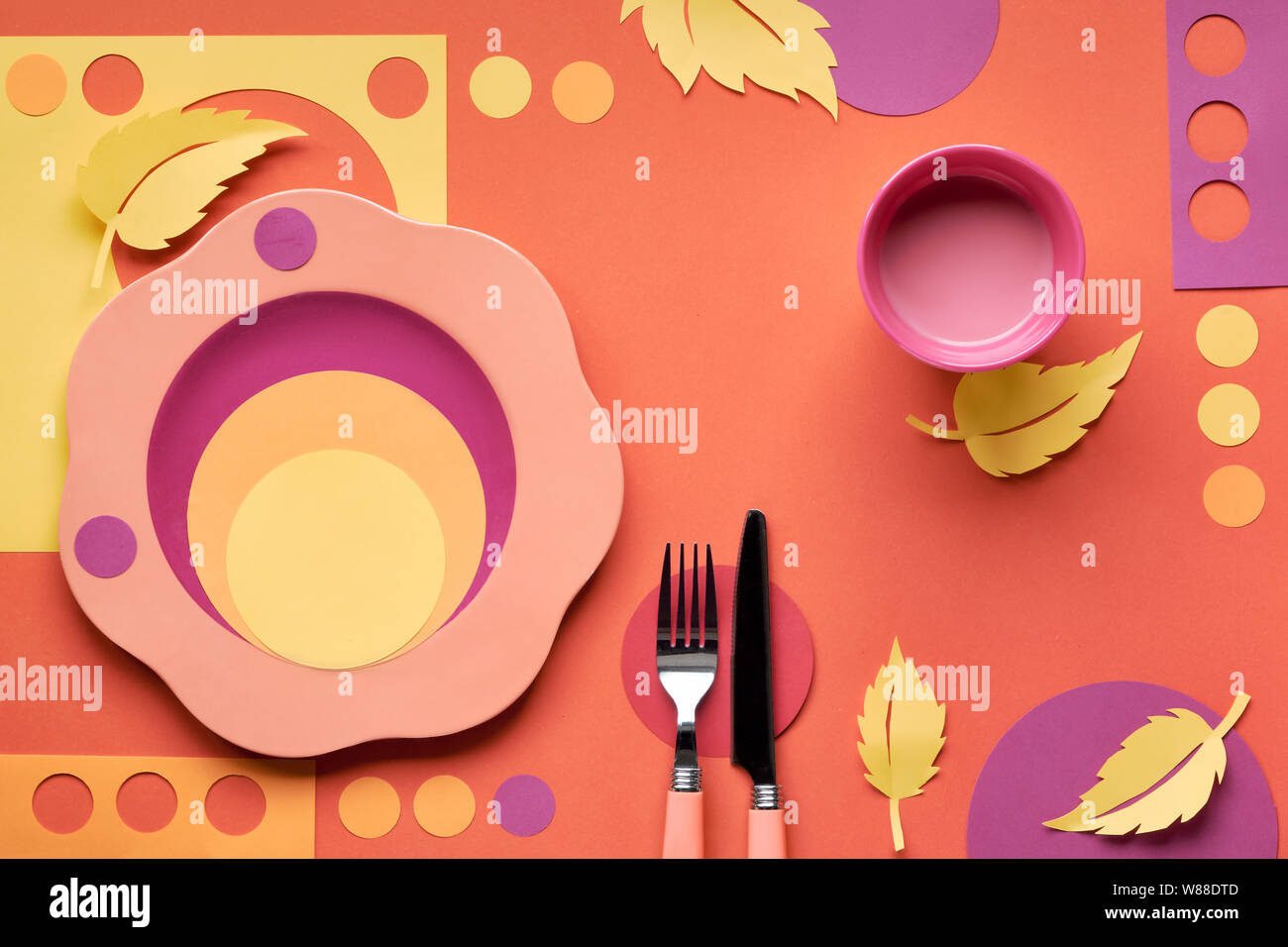 Autumn concept flat lay in bold colors with plate, fork, knife and ...