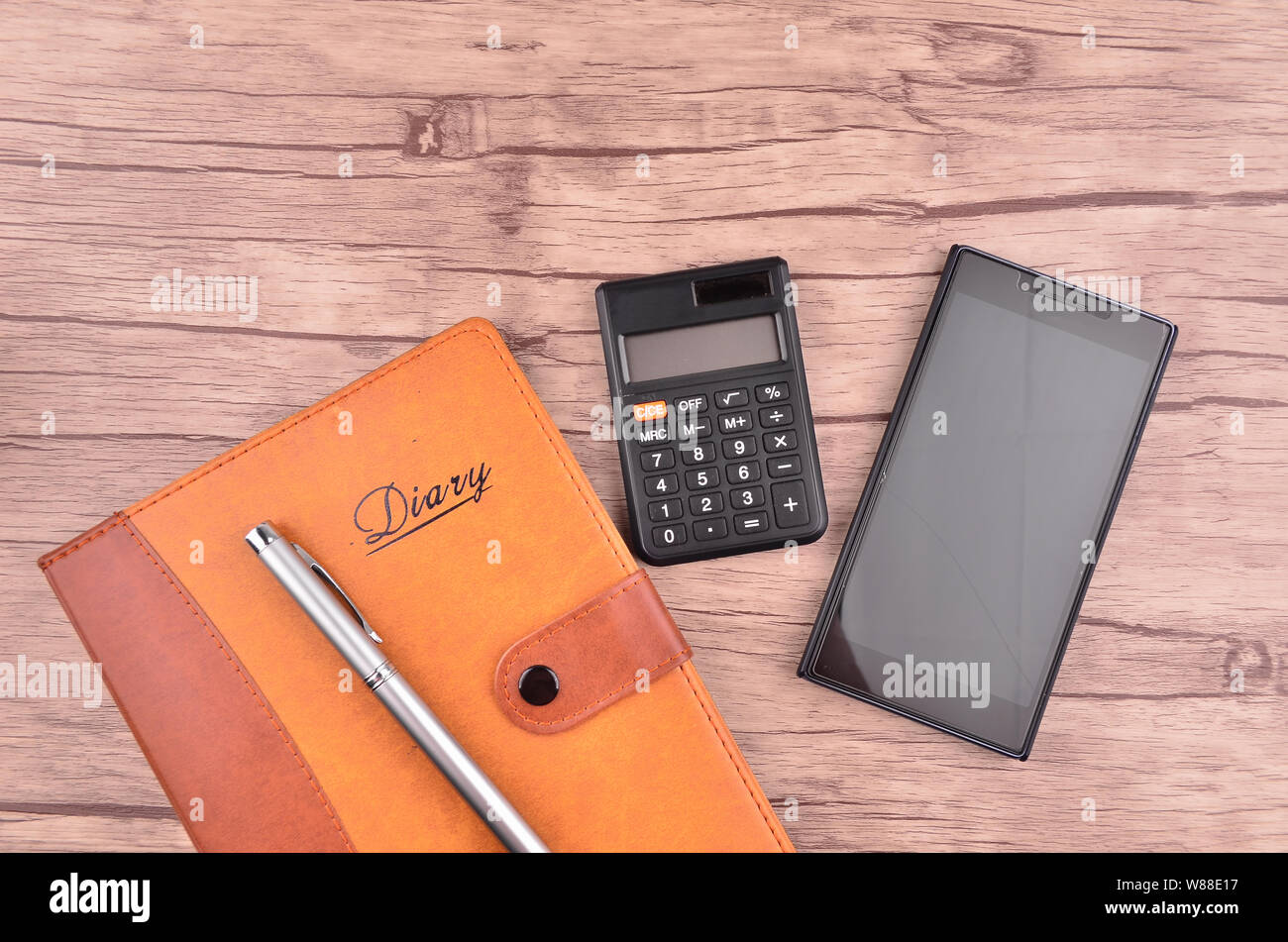 Diary with pen, smart phone, and calculator on wood table Stock Photo ...