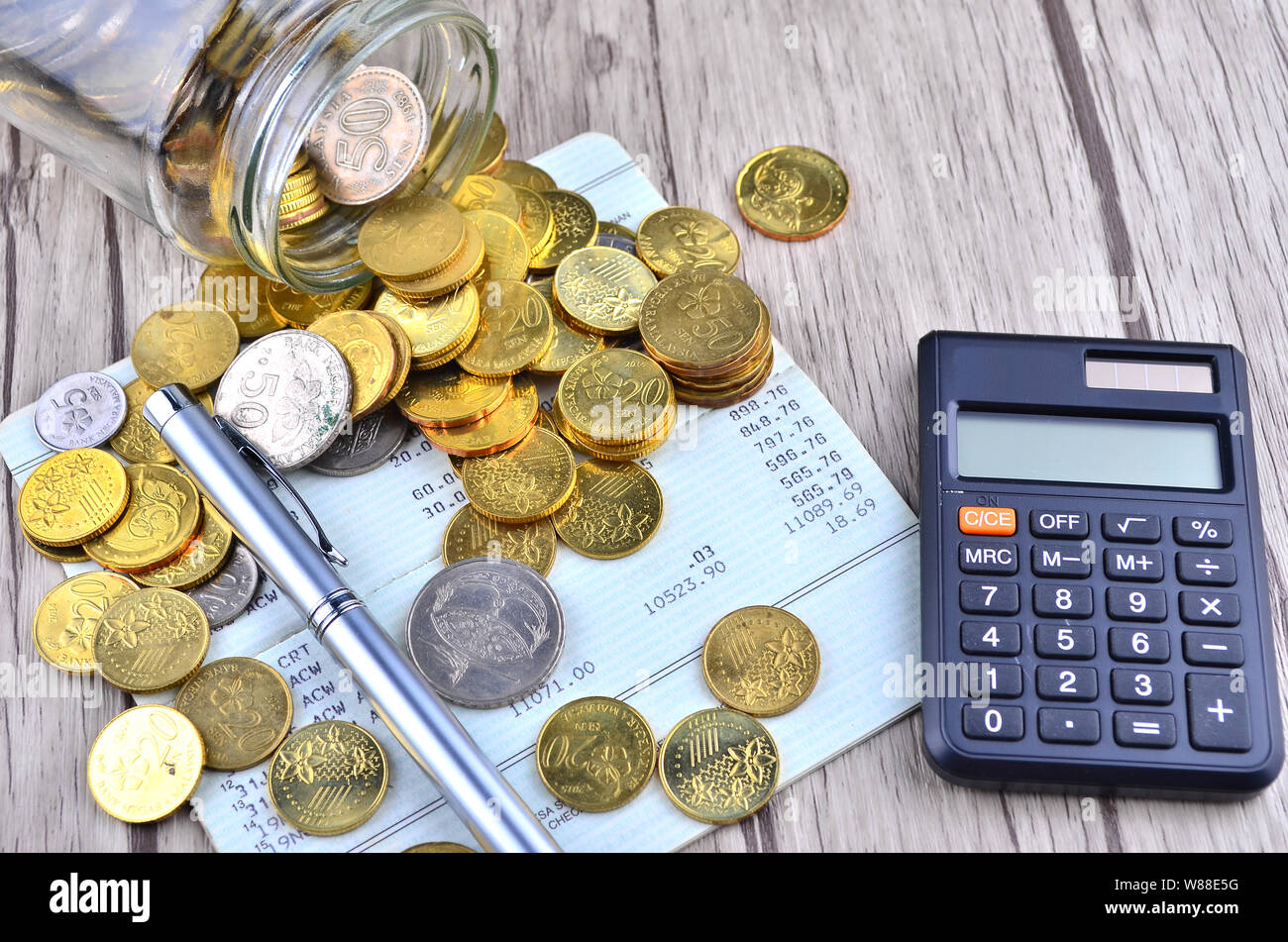 Coins, calculator and pen on bank account book Stock Photo - Alamy