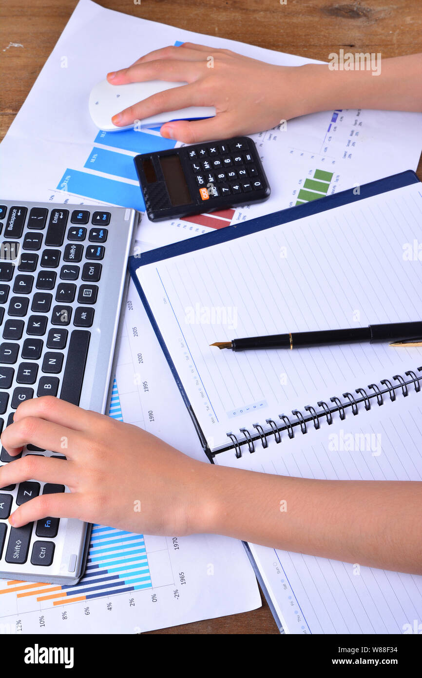 Hand on keyboard and mouse with graph, chart on wooden table Stock ...