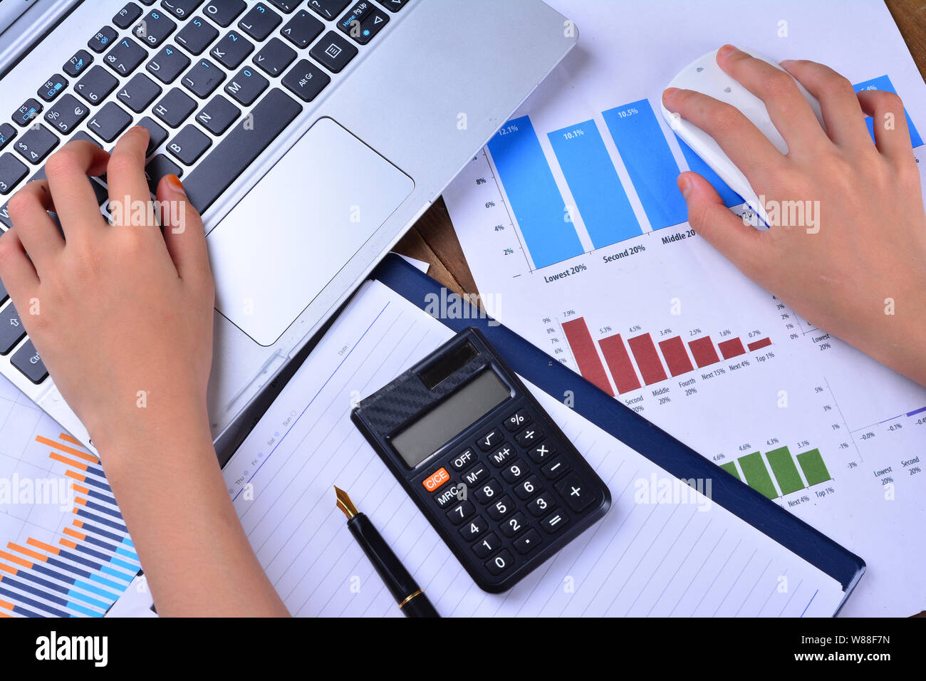 Hand on keyboard and mouse with graph, chart on wooden table Stock ...
