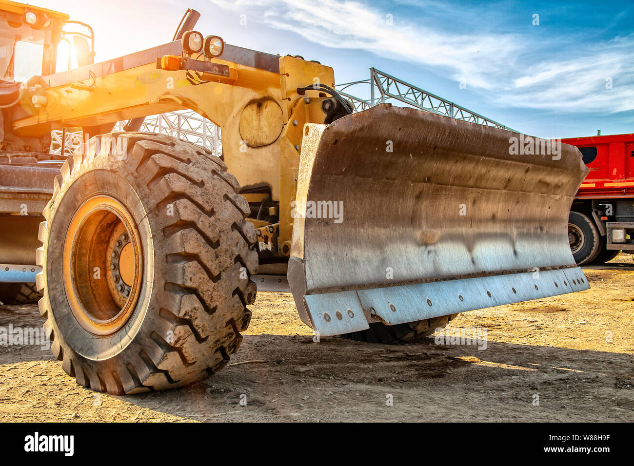 Grader clearing and leveling construction site surface. Grader ...