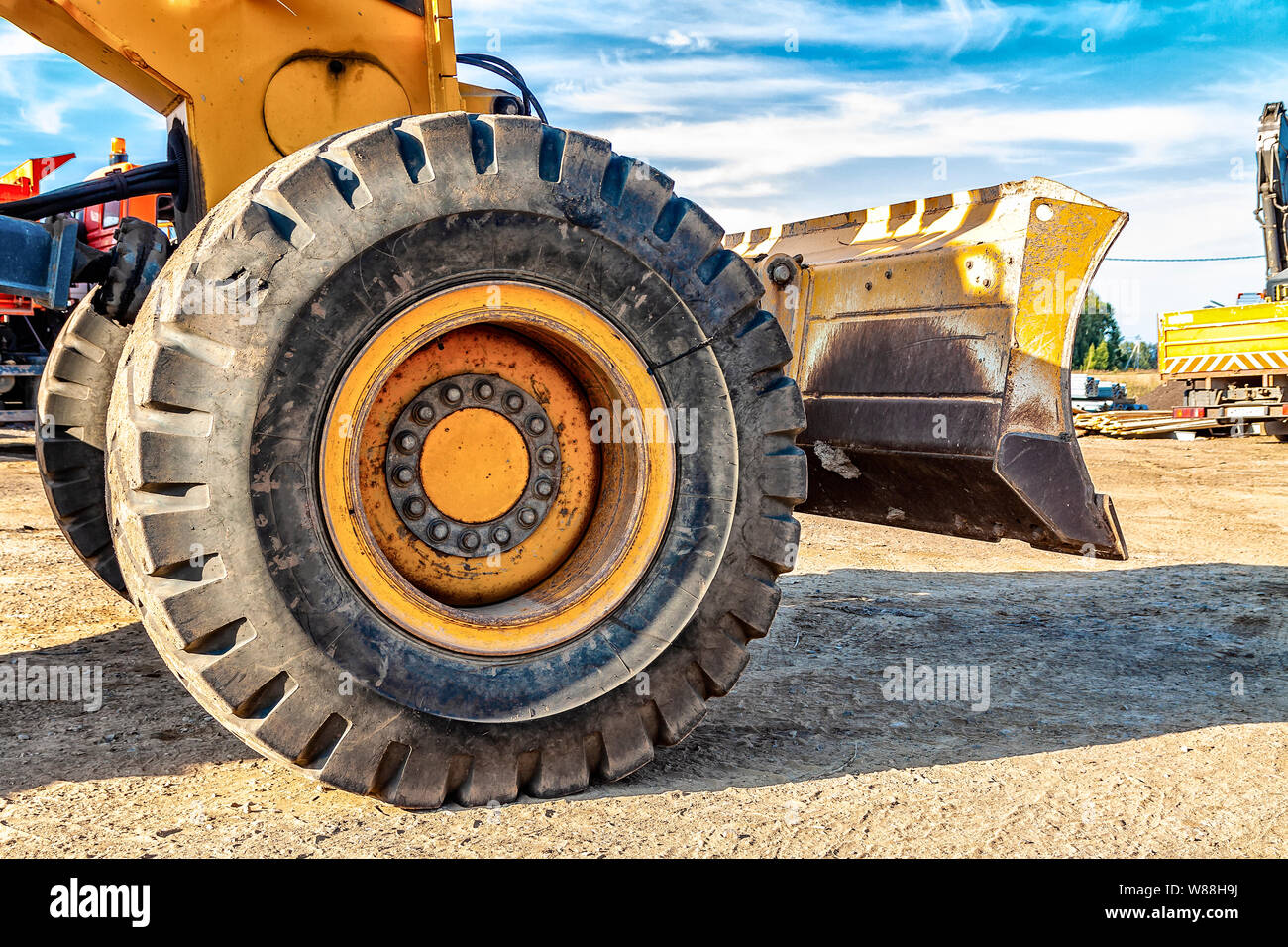 Large wheel of a yellow grader close-up Stock Photo - Alamy