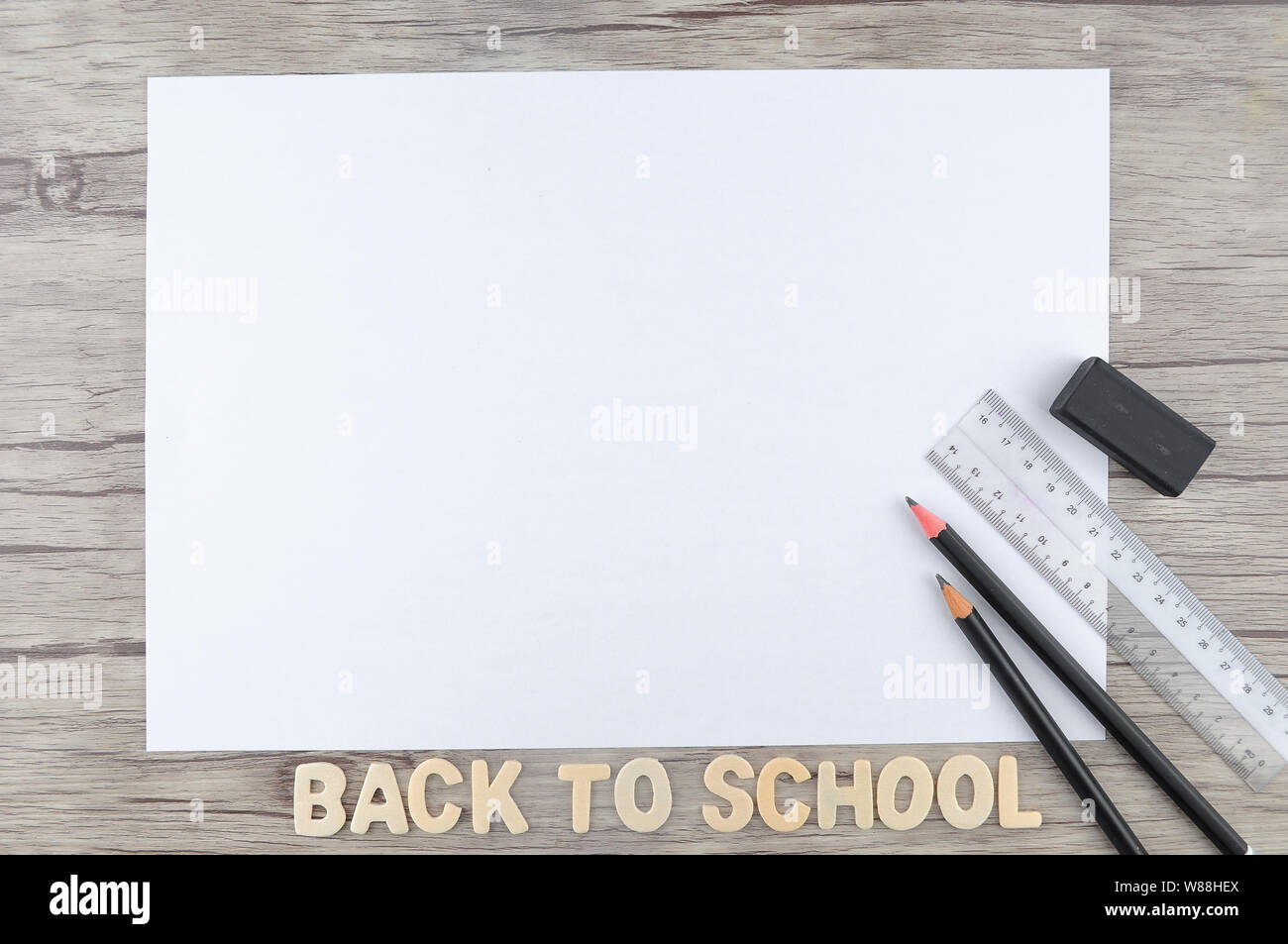 Pencil, eraser and ruler with blank paper on wooden background - Back ...