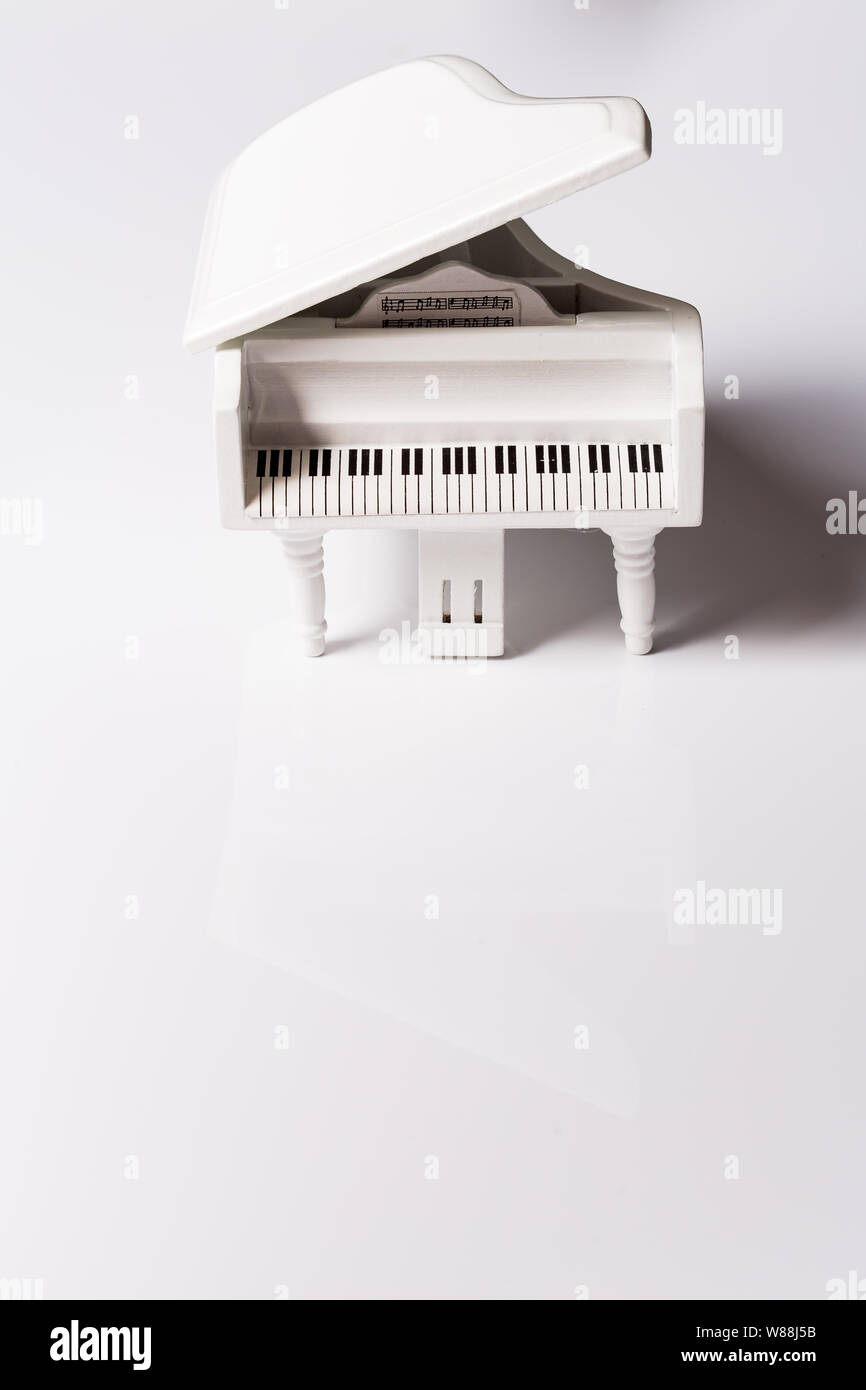 White small toy piano keyboard on a white background Stock Photo - Alamy