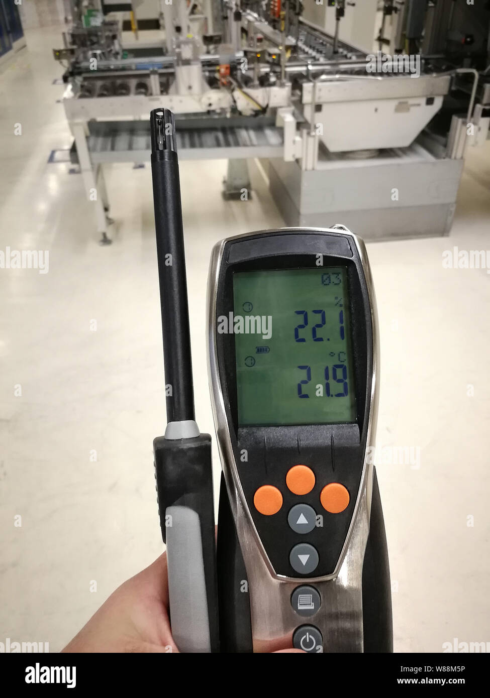 The hand of a person holds a device for measuring temperature and ...