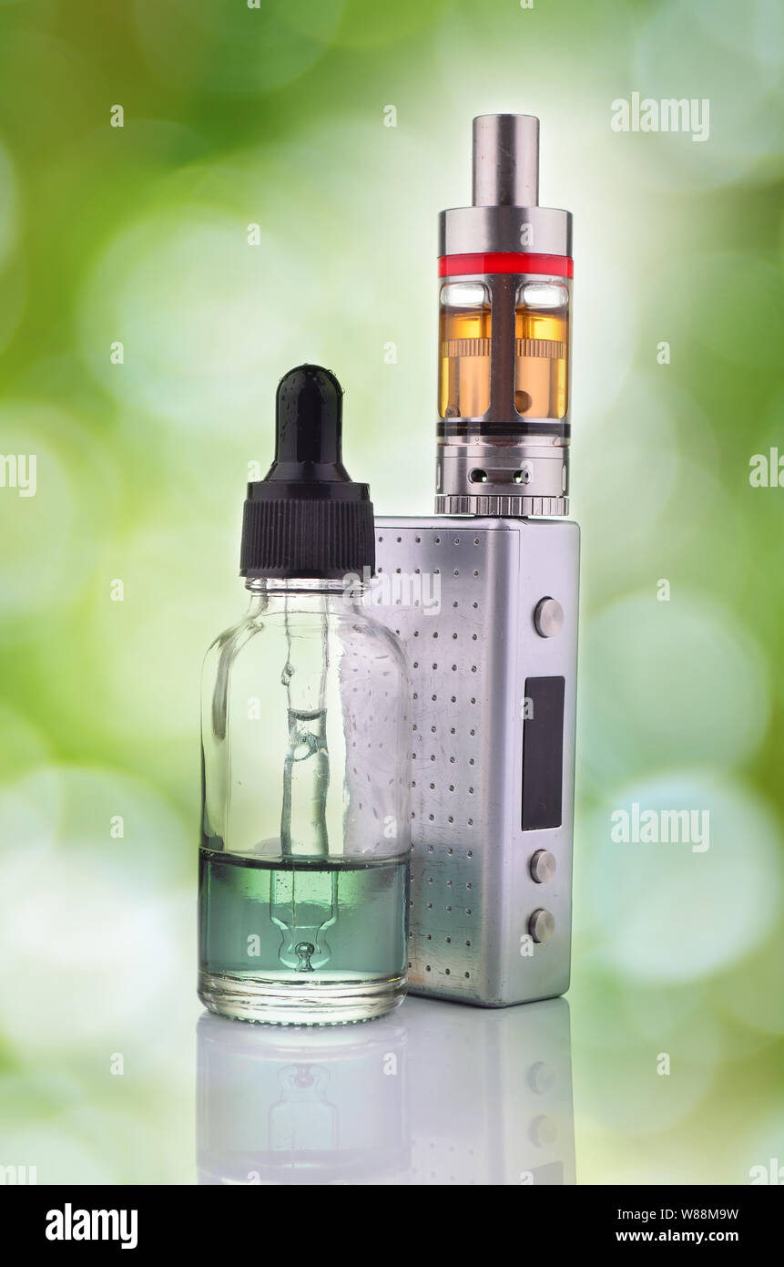 E-cigarette or vaping device over green blur background Stock Photo - Alamy
