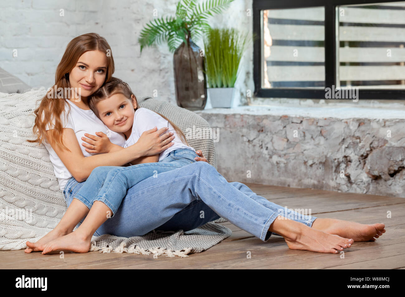 Indoor portrait of a beautiful mother with her charming little daughter ...