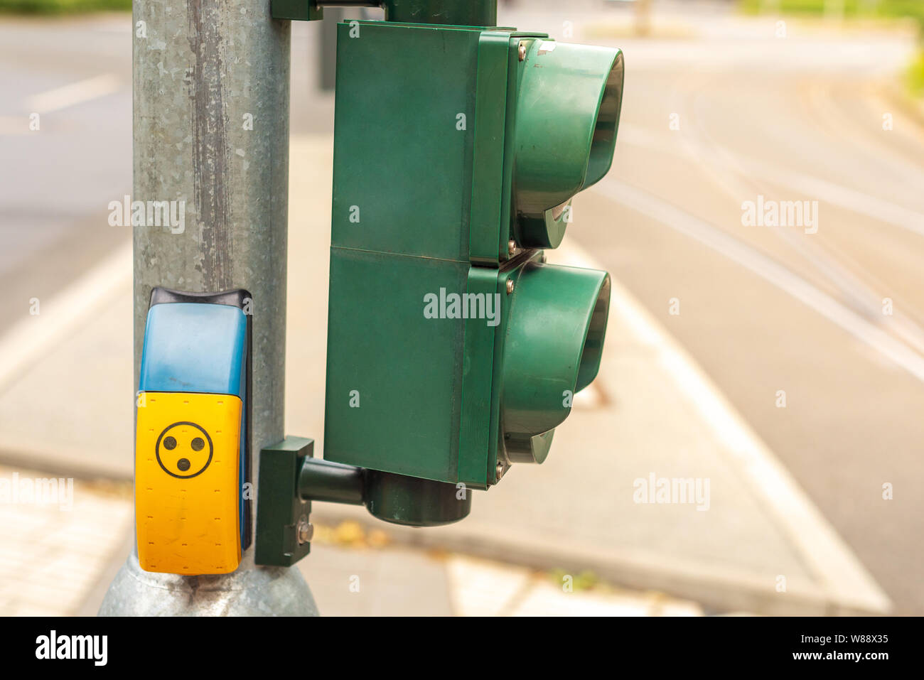 Yellow pedestrian crossing sign or crosswalk push button set up on ...