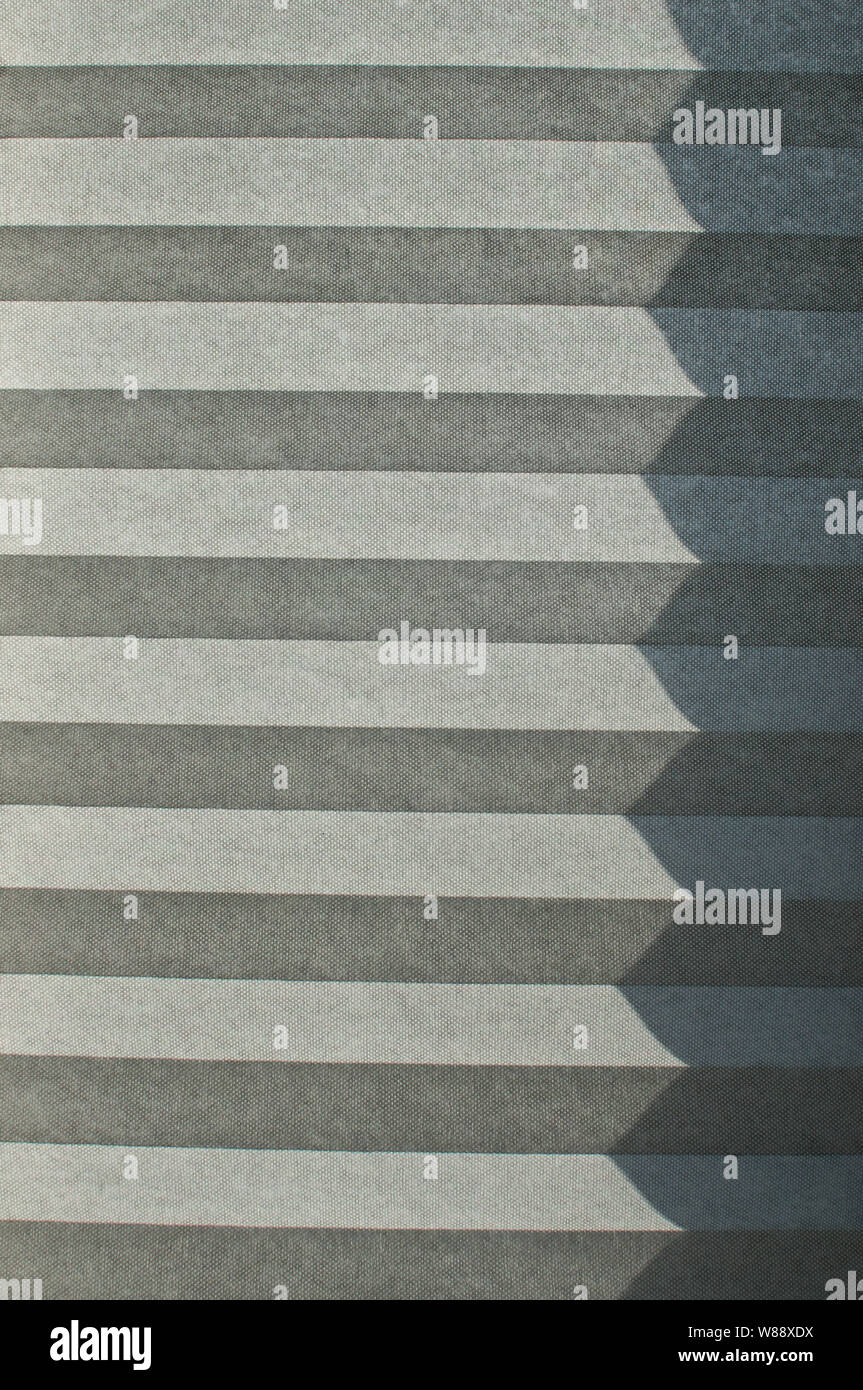 Folded textile window blind lit by sunlight closeup as background Stock ...